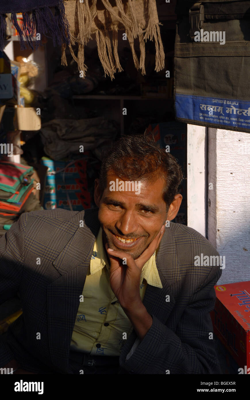 Man sitting outside shop in Rajasthan looking at camera Stock Photo - Alamy