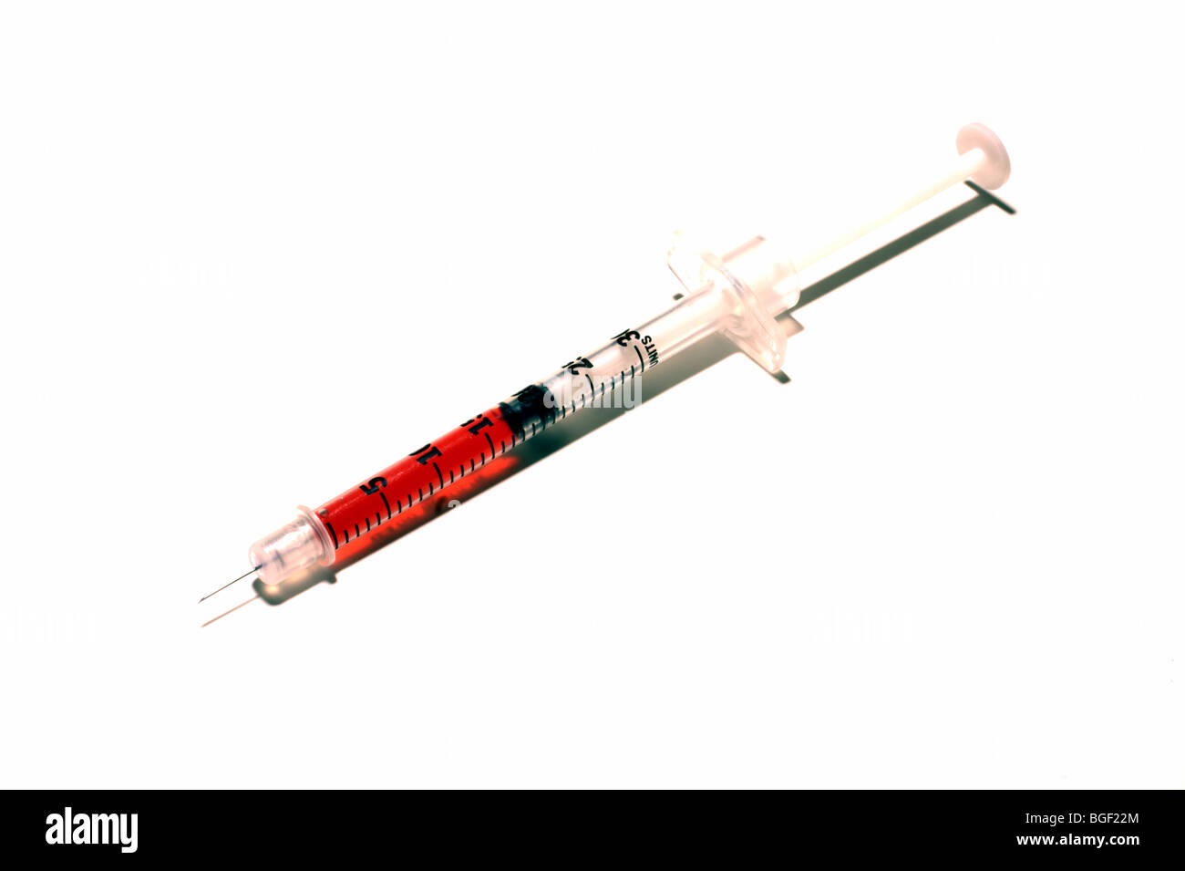 Syringe full of red liquid against white background Stock Photo - Alamy