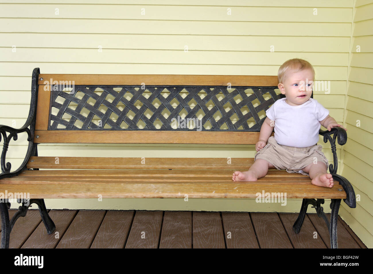 One baby sitting on the end of a bench Stock Photo - Alamy