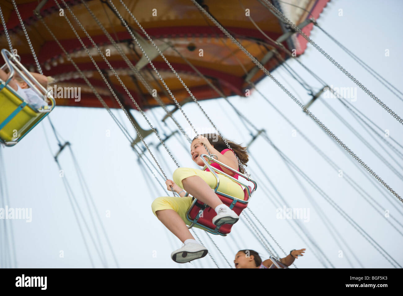 Girl riding the spinning swing at an amusement park Stock Photo - Alamy