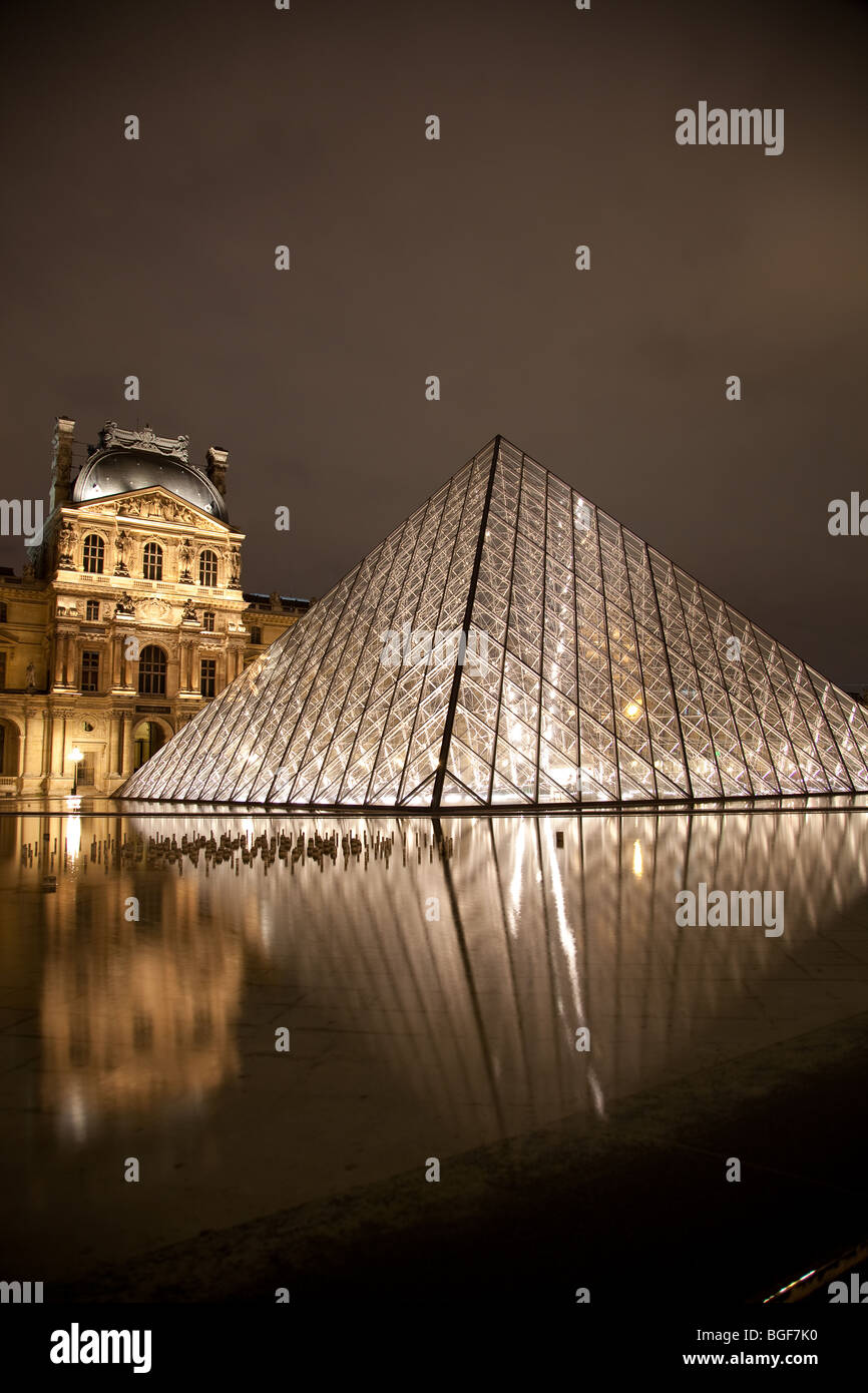 Louvre Museum and Triangle Pyramid lit up at night with fountain Stock ...