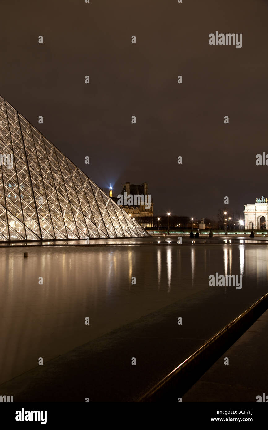 Louvre Museum and Triangle Pyramid lit up at night with caousel and ...