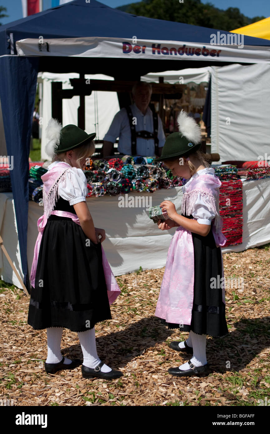 Two girls looking in their traditional clothing standing outside shop ...