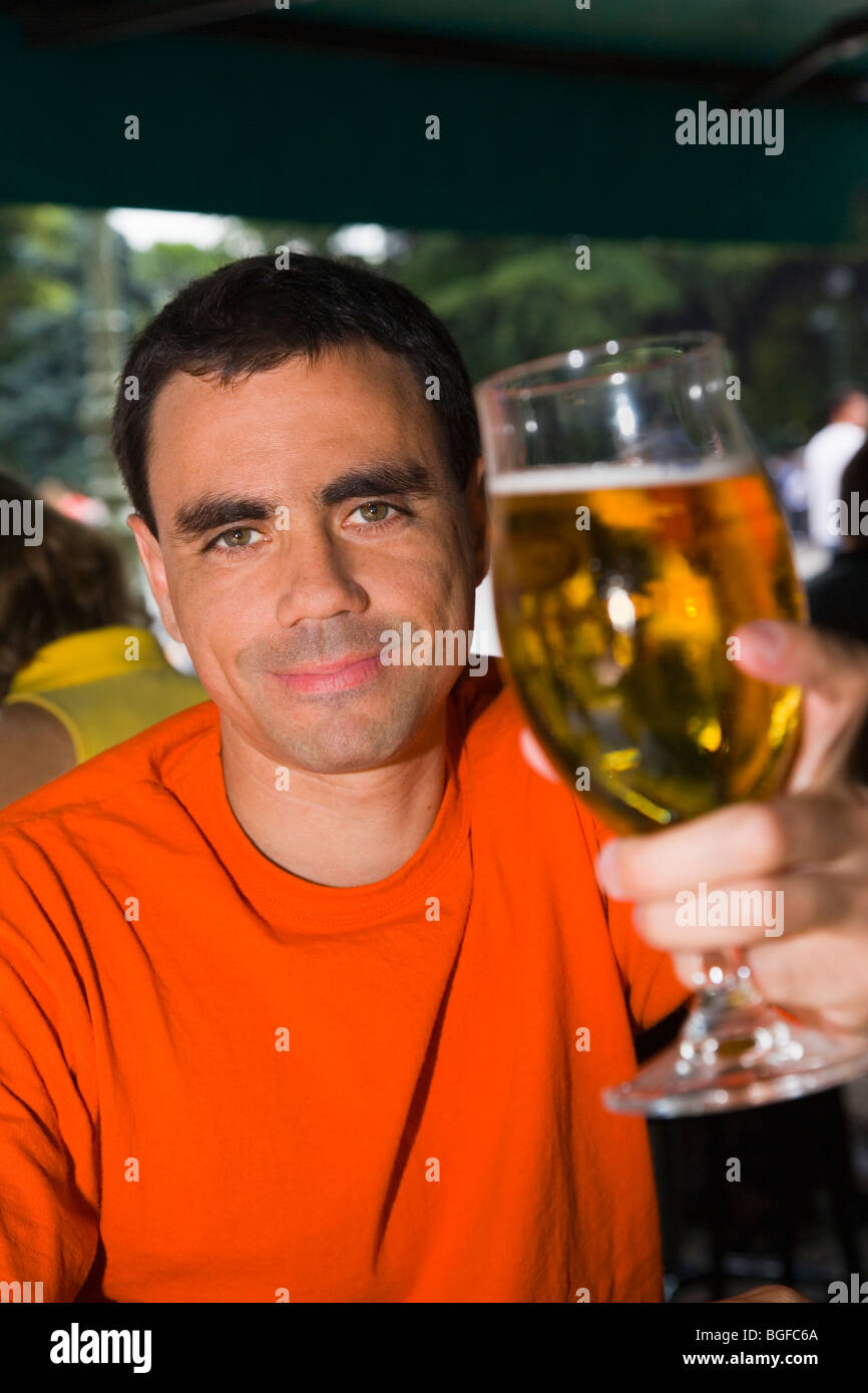 Man drinking beer in an outdoor cafe, smiling, portrait, Verona, Italy ...