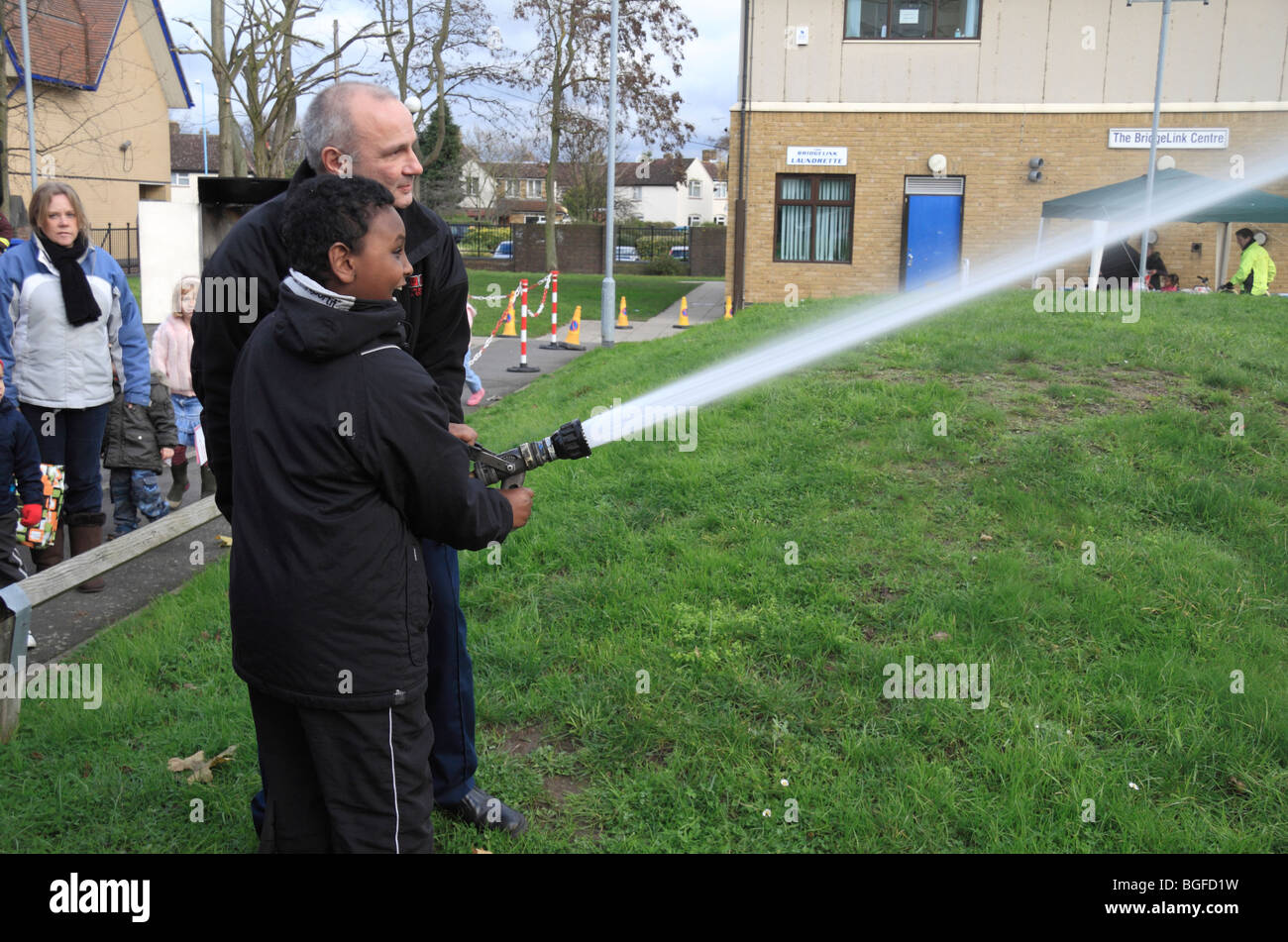 A child has a go with a firefighting water hose at a London Fire ...