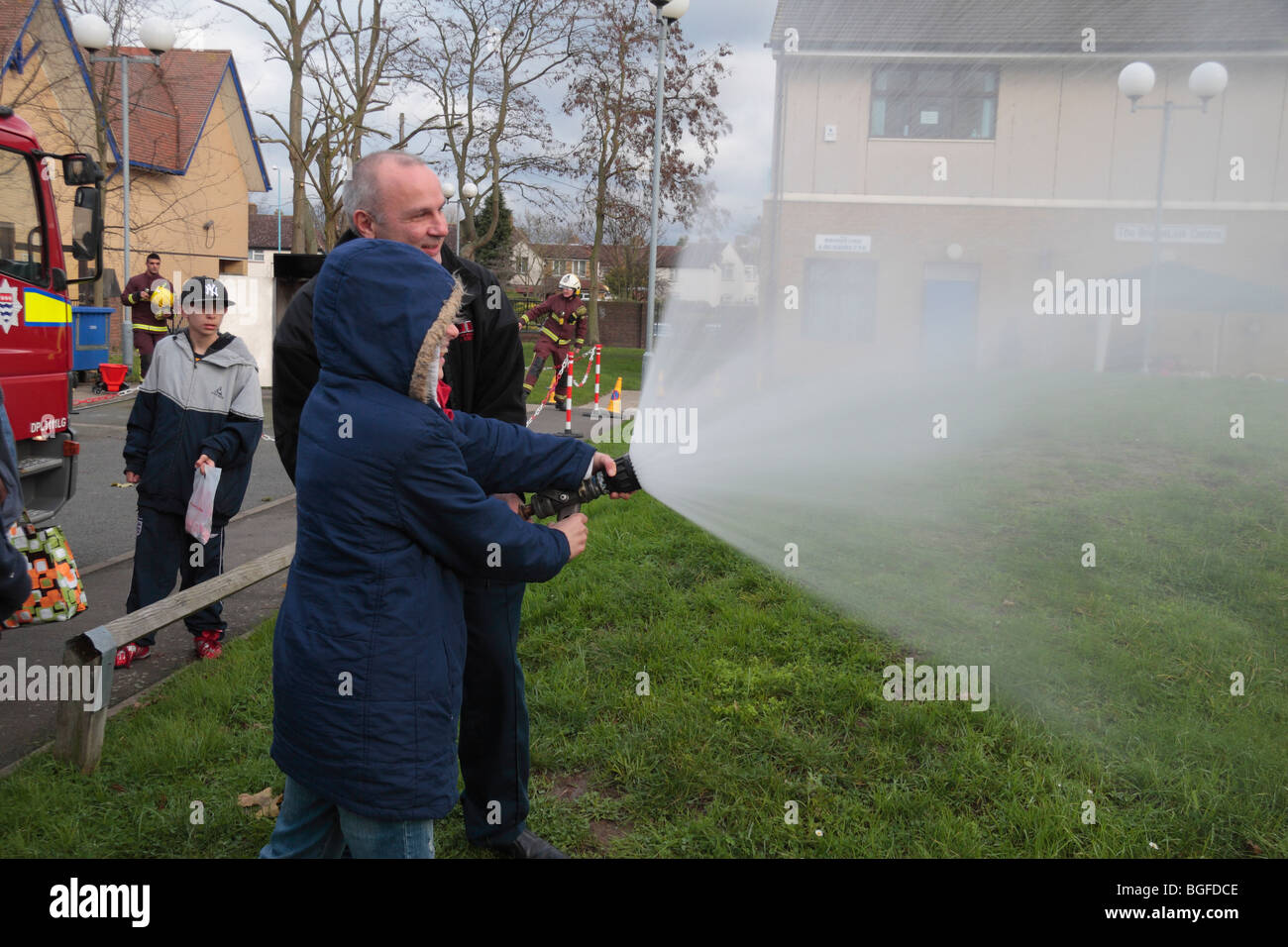 A child has a go with a firefighting water hose at a London Fire ...