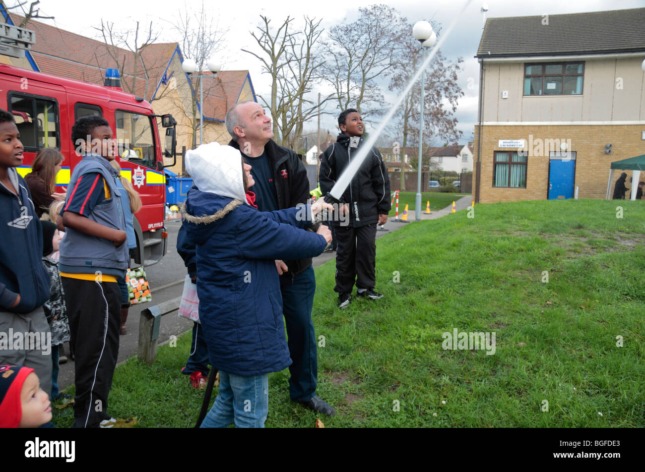 A child has a go with a firefighting water hose at a London Fire ...