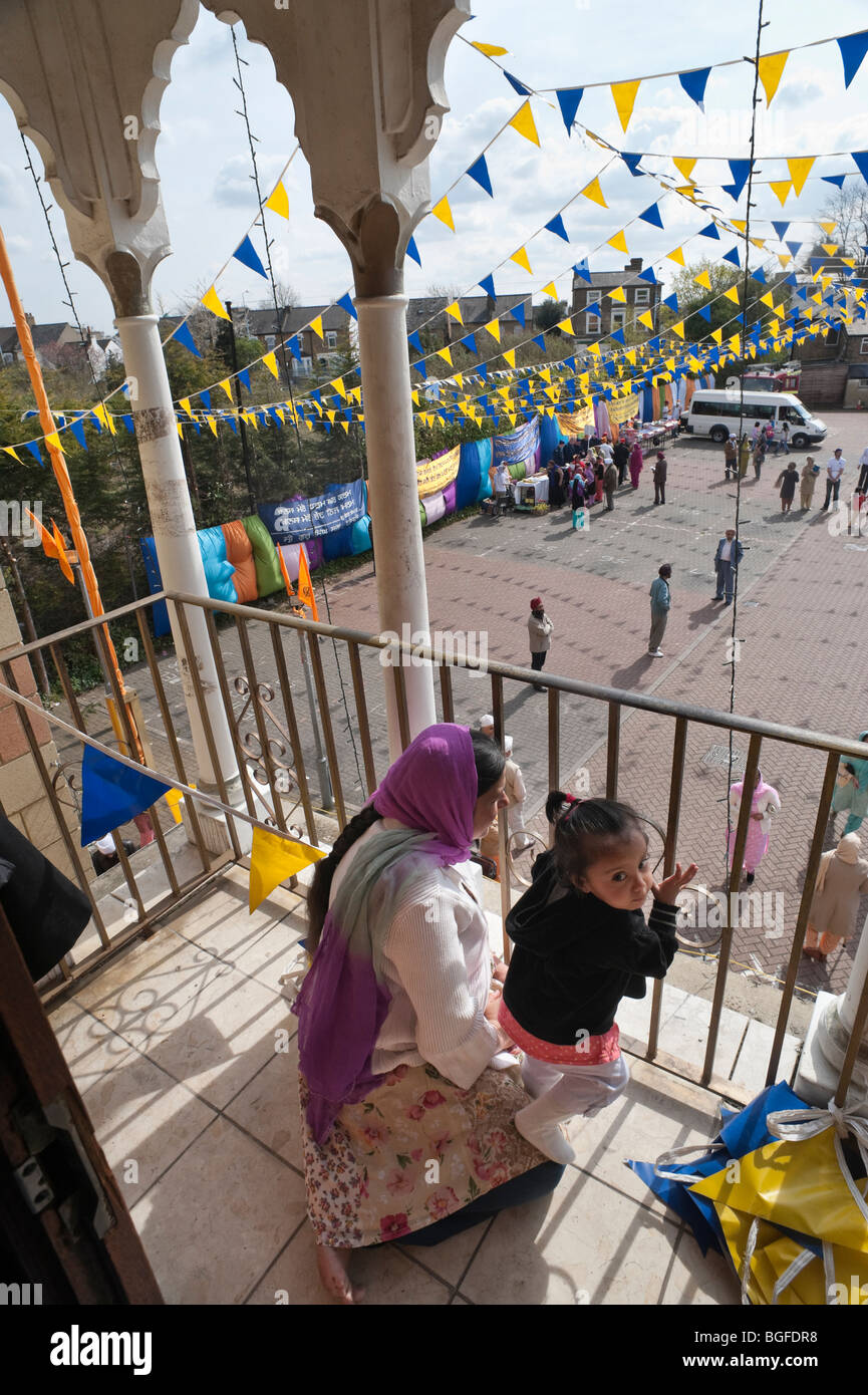 Sikh woman and child look down from balcony of Gurdwara at Hounslow ...