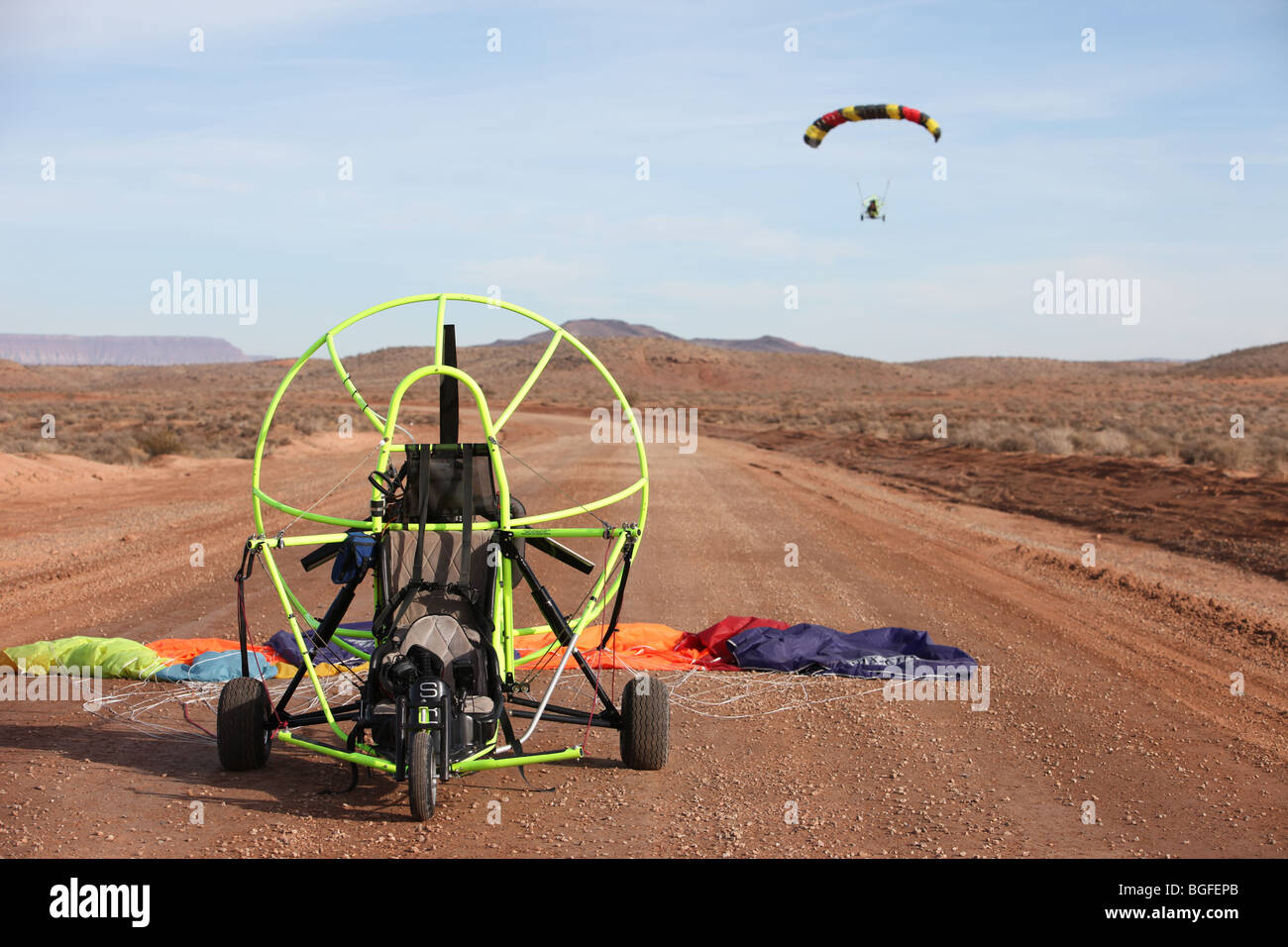 Power parachute flying near aircraft on ground in desert area of ...