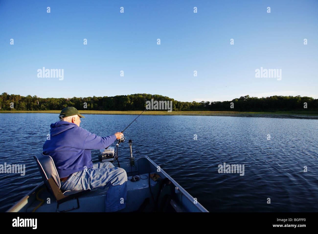 Senior elderly seasoned fishing guide casting fighting battling fish ...