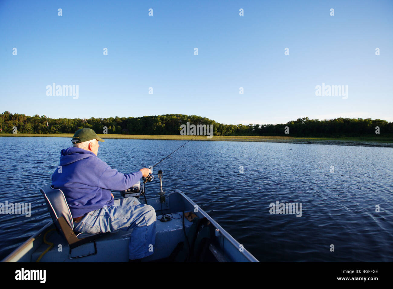 Senior elderly seasoned fishing guide casting fighting battling fish ...