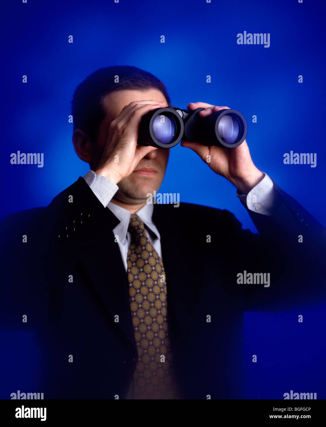 A business man wearing a suit looking through binoculars Stock Photo ...