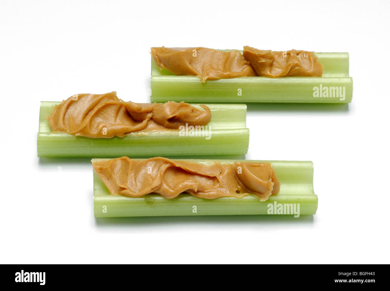 Three short pieces of celery the peanut butter applied Stock Photo - Alamy