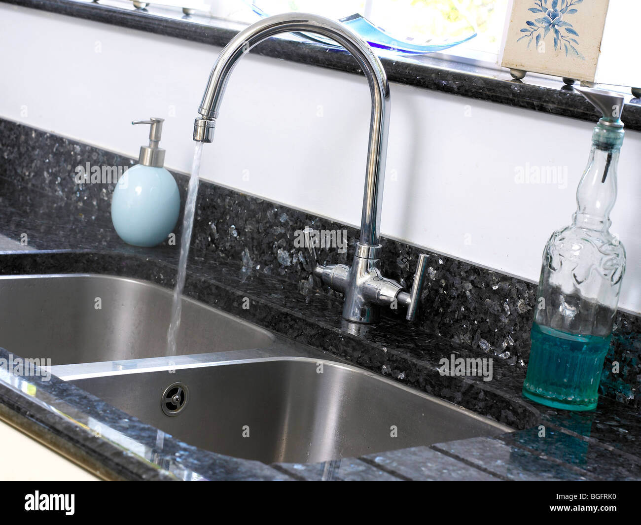 A double stainless steel sink and tap in a kitchen Stock Photo - Alamy