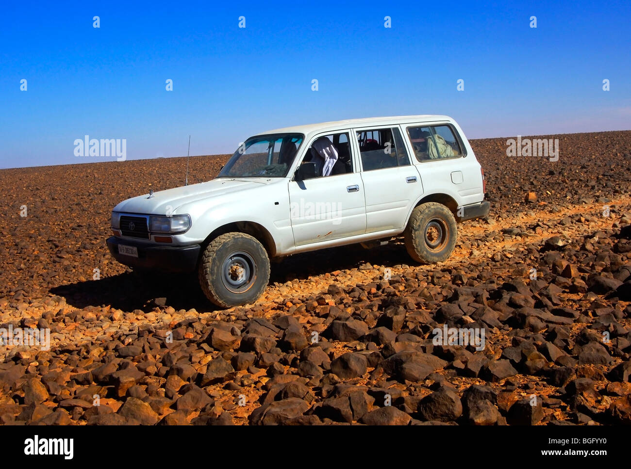 Four-wheel drive car in a stony desert on the Messak Settafek plateau ...