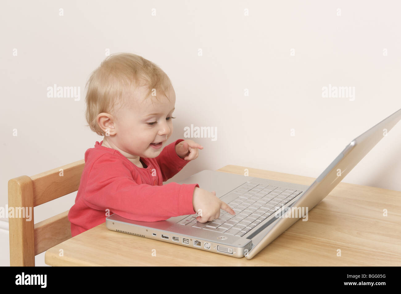 Toddler at table using laptop computer Stock Photo - Alamy