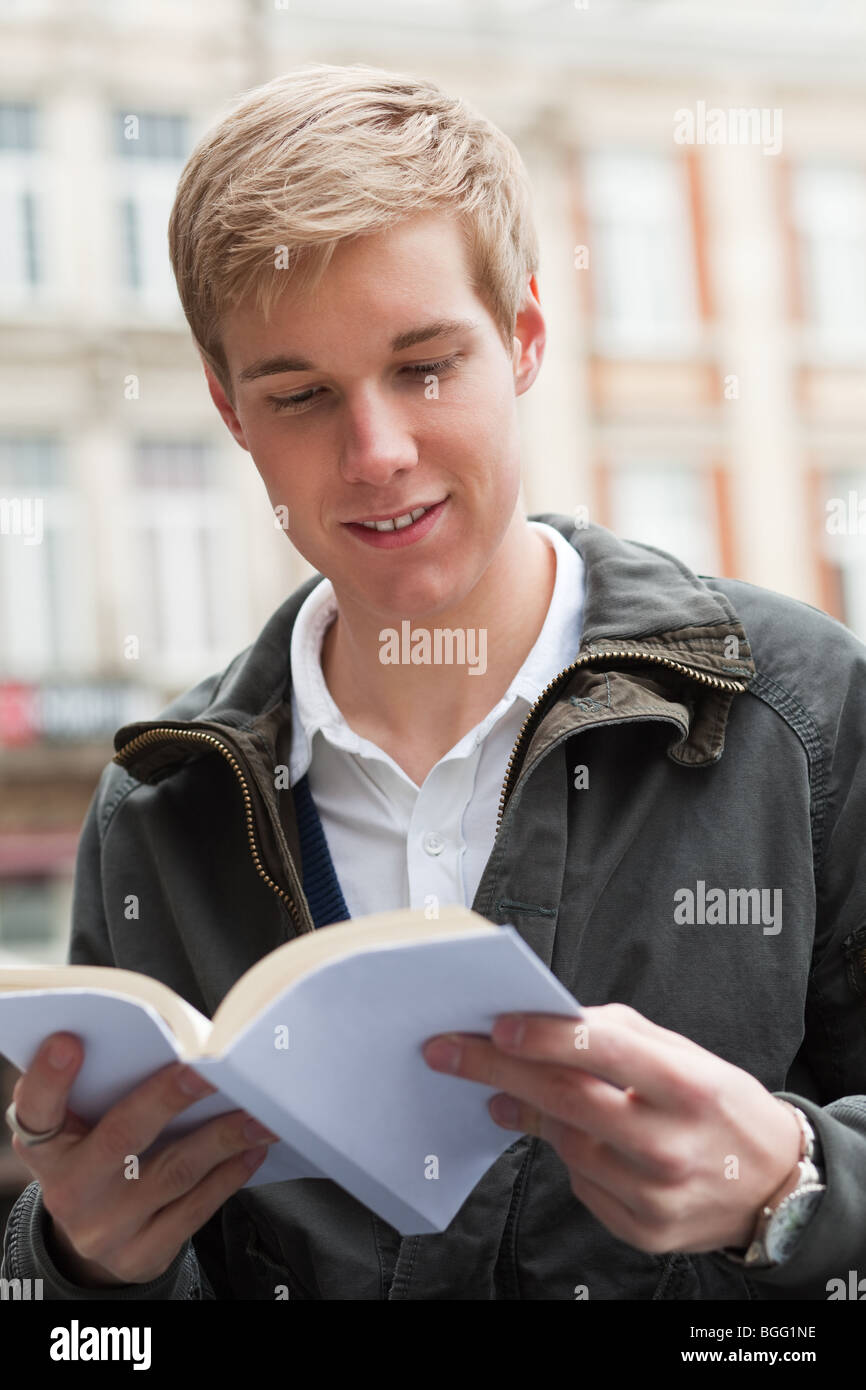 Young cheerful handsome guy reading a book with blank cover Stock Photo ...