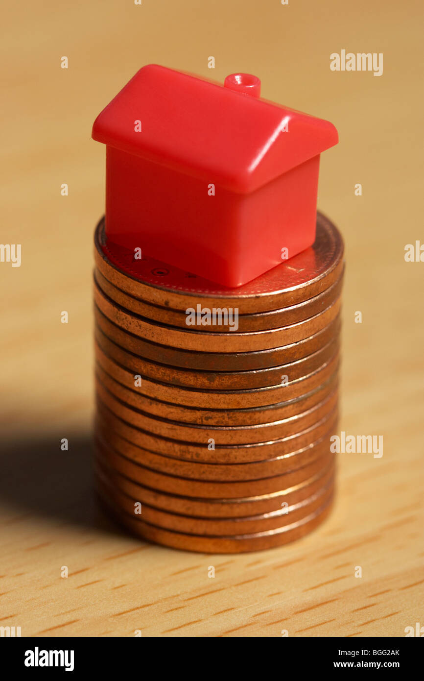 small model toy house on a stack of penny coins Stock Photo - Alamy