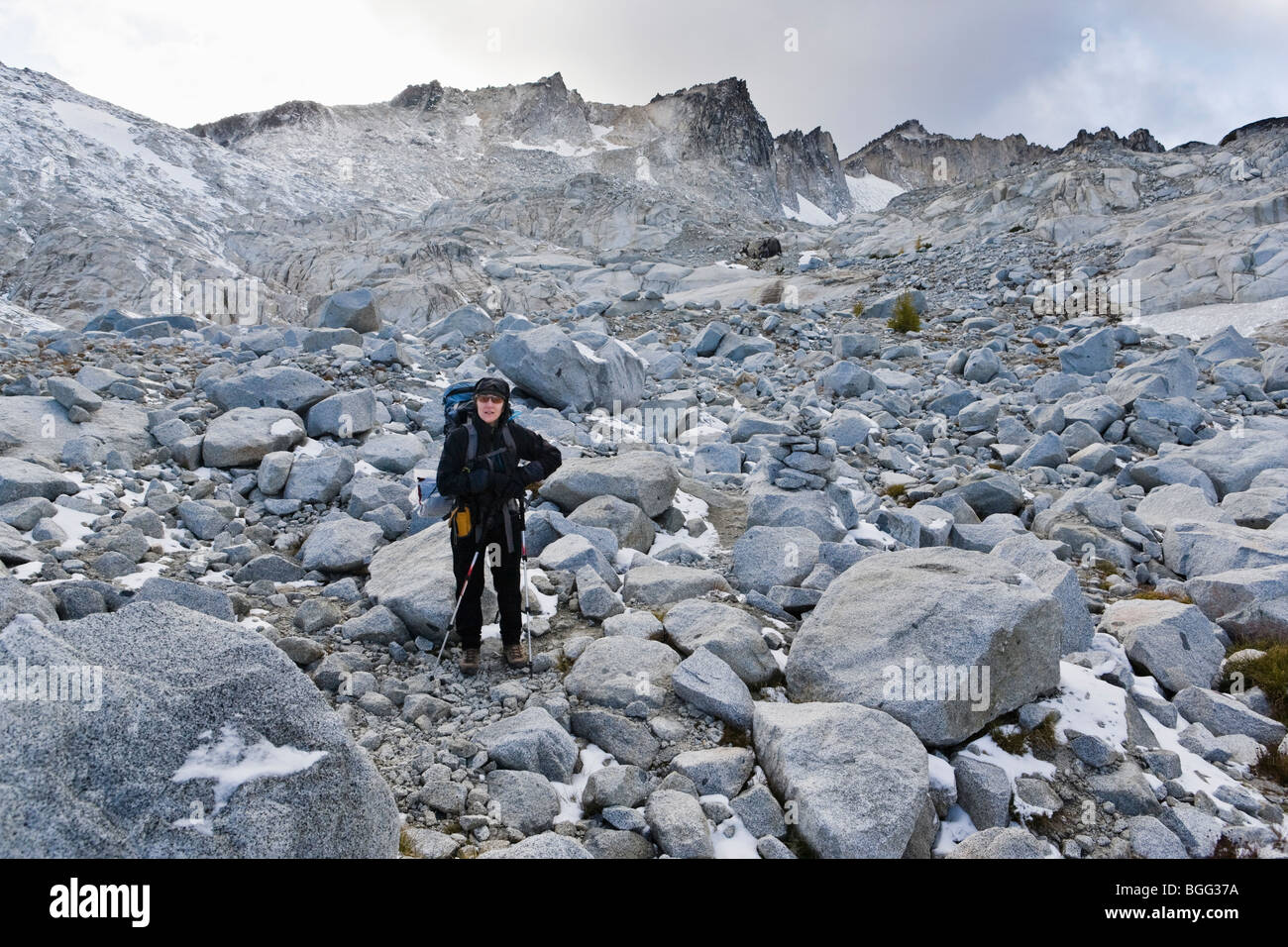 A woman backpacker standing in a boulder / talus field in the Upper ...