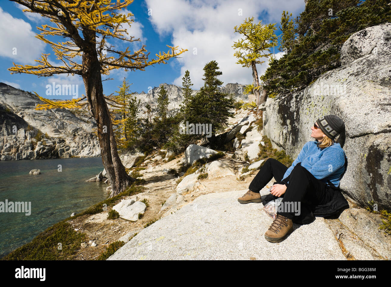 A woman sitting and relaxing next to Perfection Lake, Enchantment Lakes ...