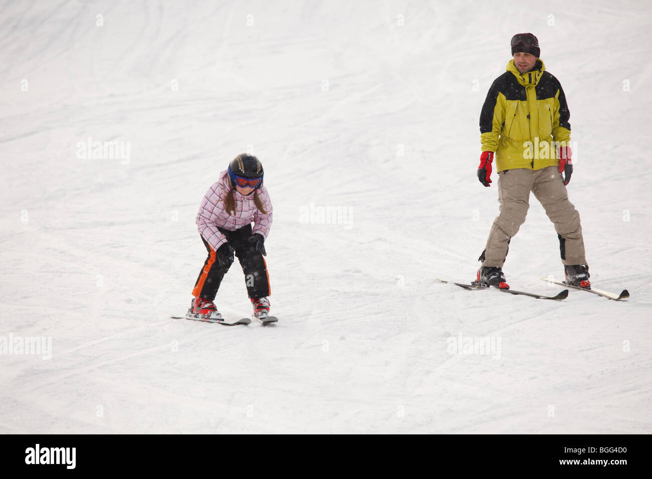 Instructor training little girl downhill alpine skiing Stock Photo - Alamy