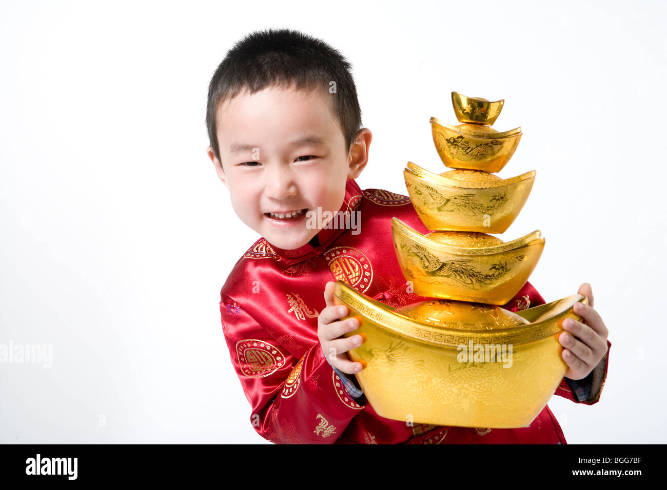 Boy in Chinese traditional clothes holding gold ingot Stock Photo - Alamy