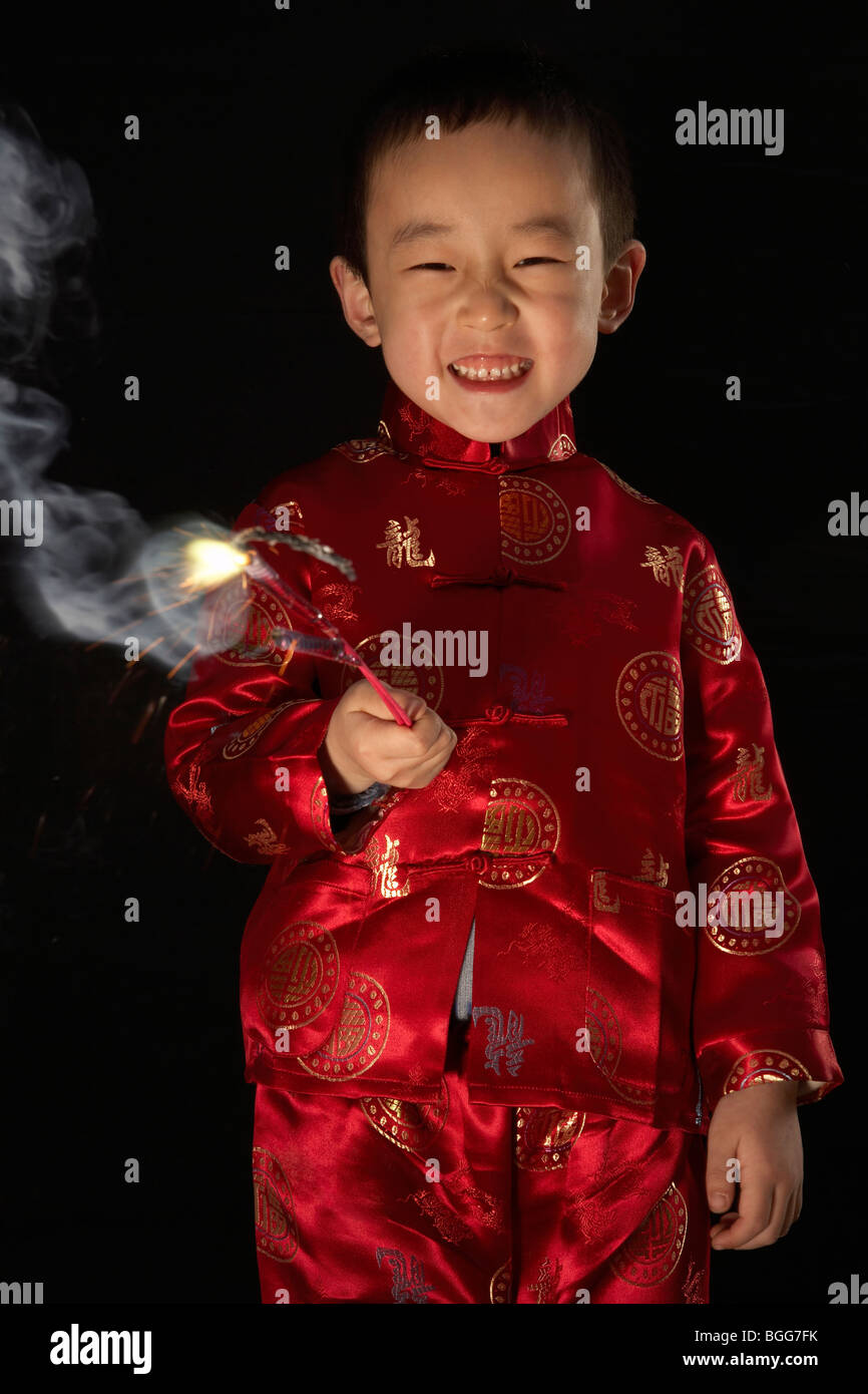 Boy in Chinese traditional clothes playing fireworks Stock Photo - Alamy