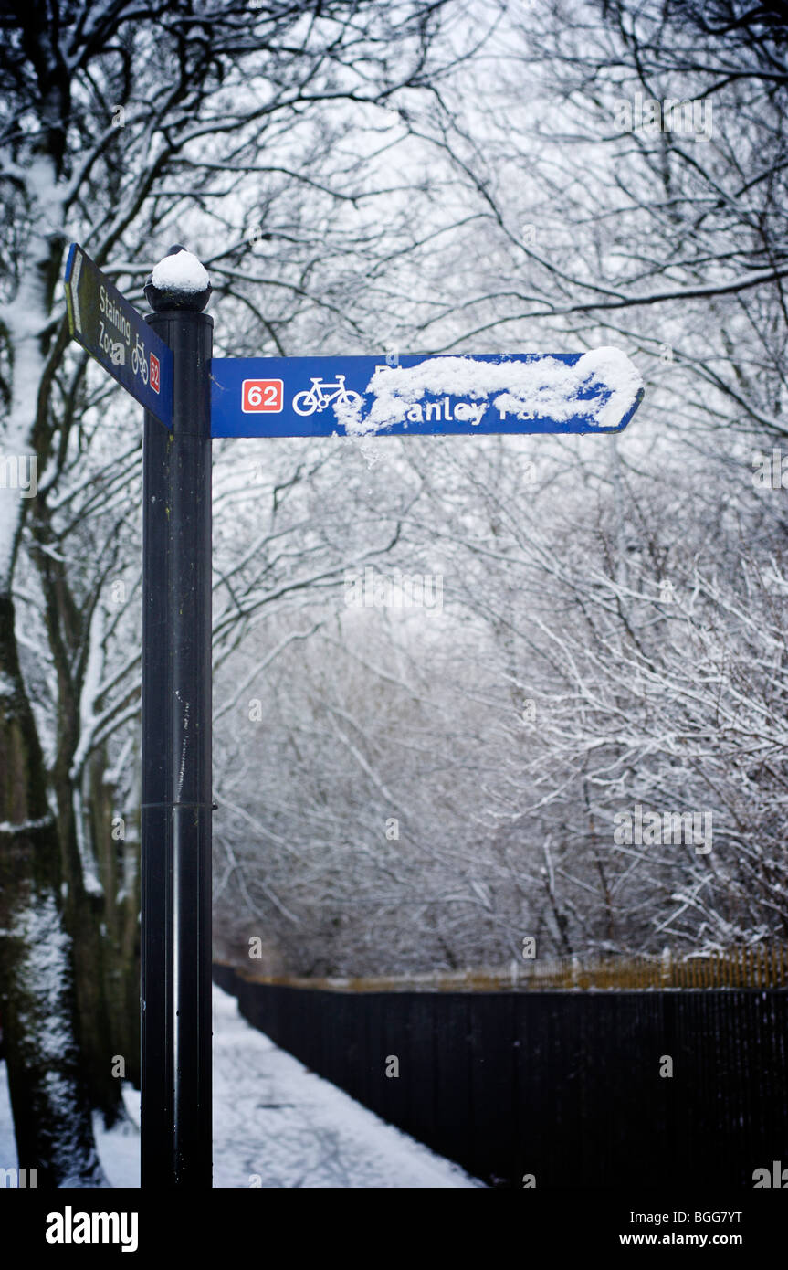 Snow partly obscuring direction sign Stock Photo - Alamy