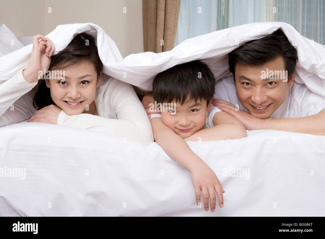 Family hiding under blanket Stock Photo - Alamy