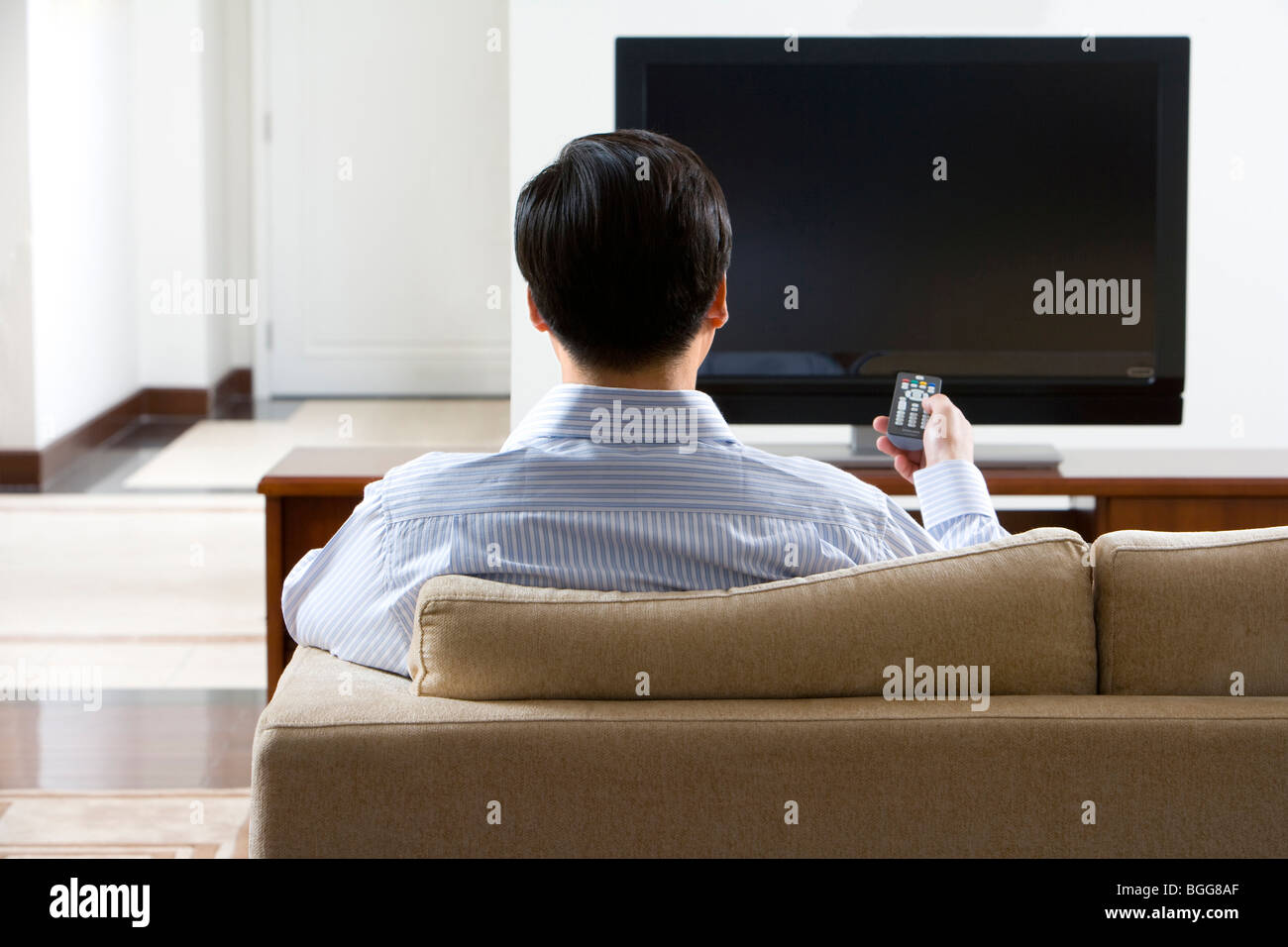 Man watching widescreen television Stock Photo - Alamy