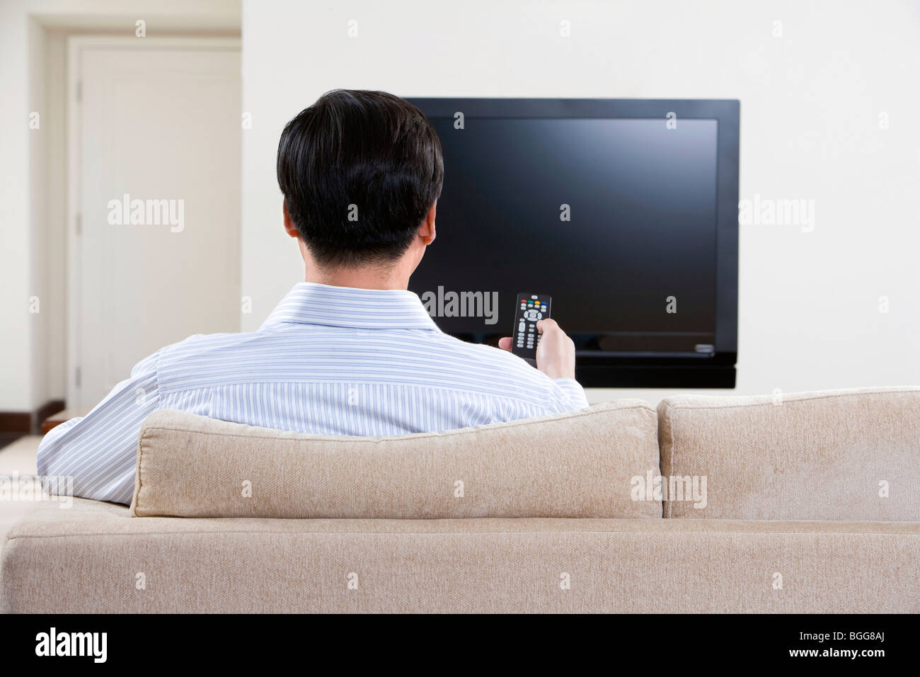 Man watching widescreen television Stock Photo - Alamy