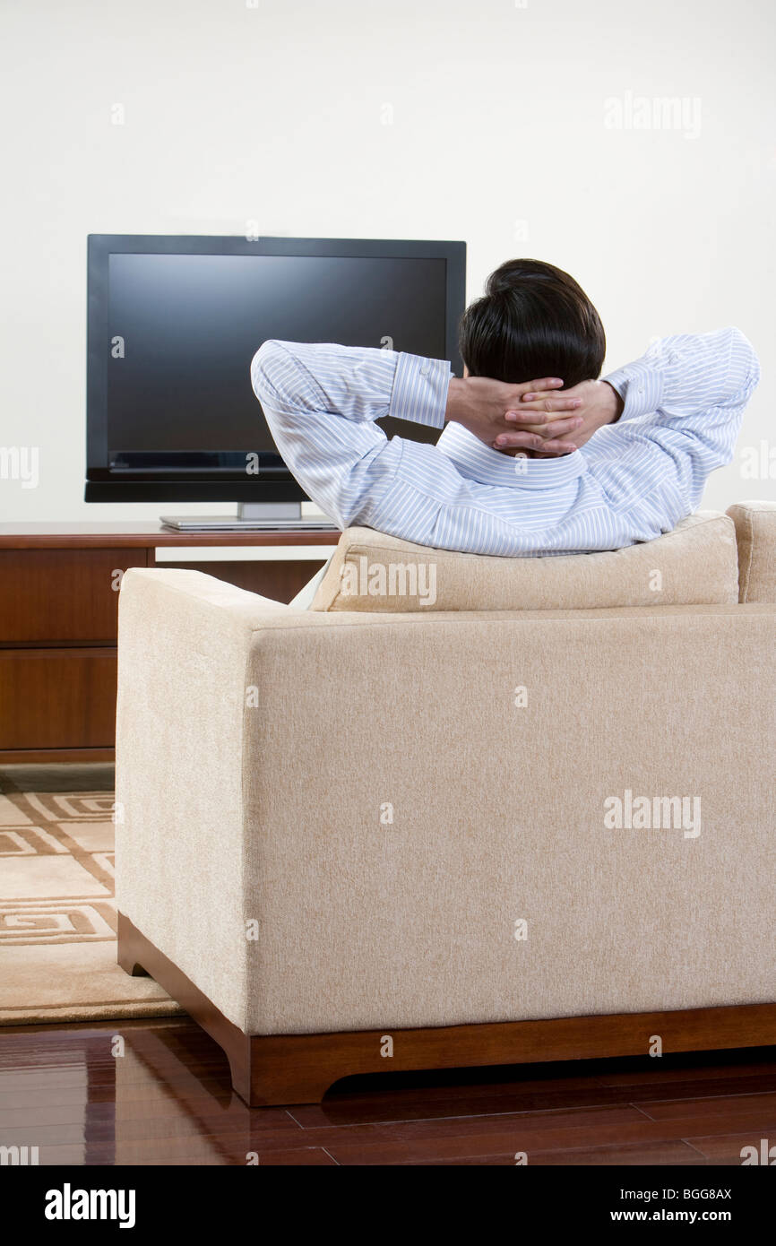 Man watching widescreen television Stock Photo - Alamy