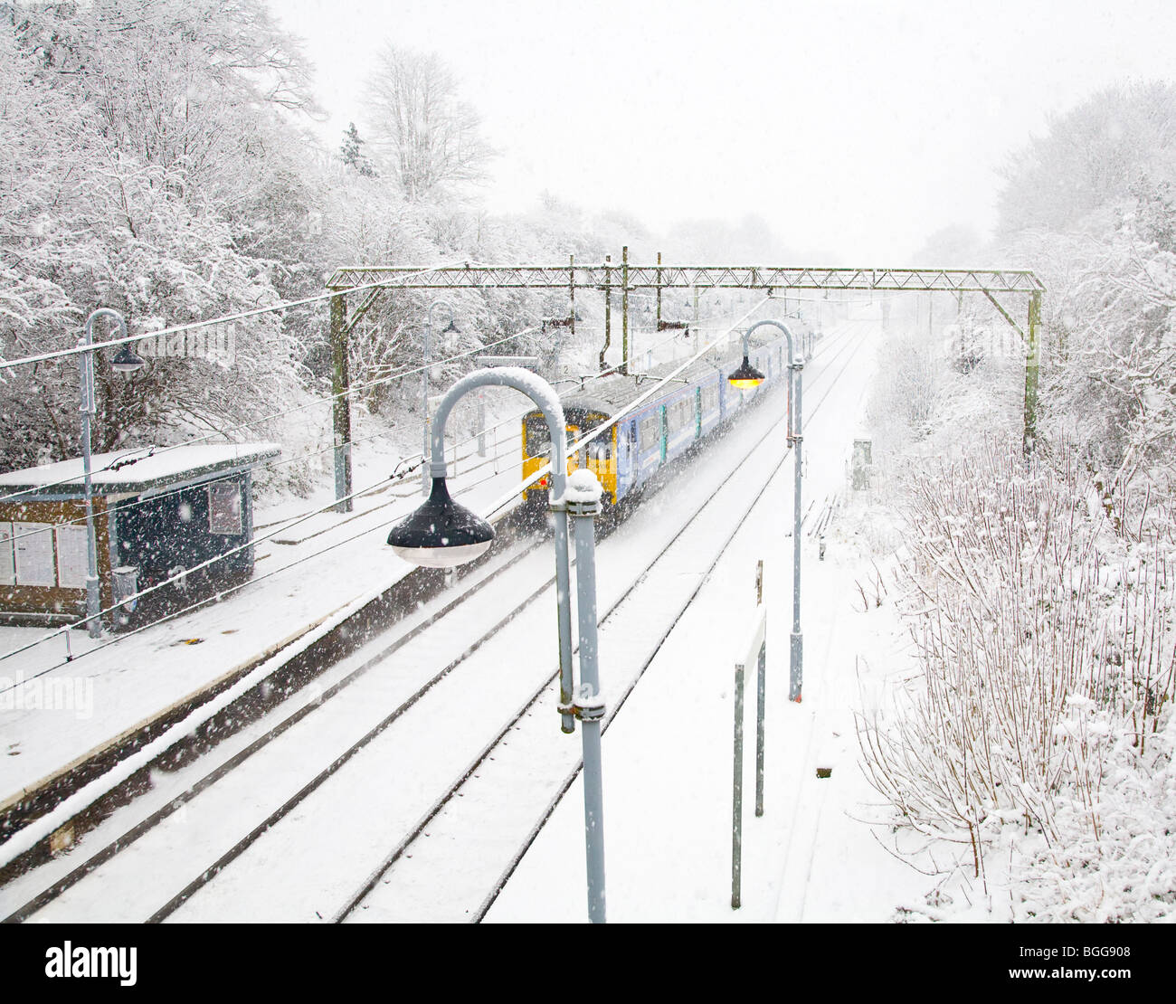 Train passing through railway station in heavy snow Stock Photo - Alamy
