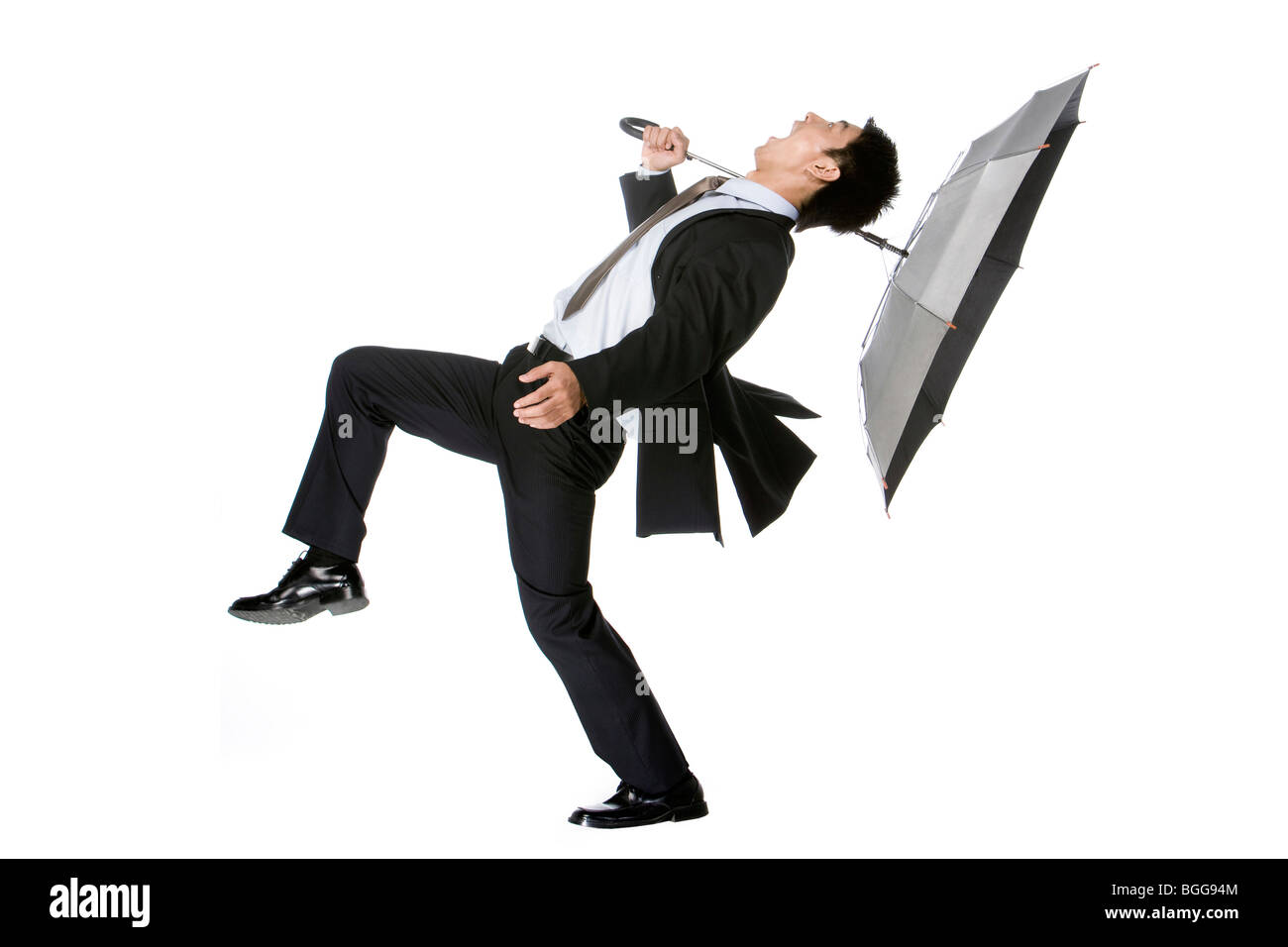 Young businessman blown away in the wind Stock Photo - Alamy