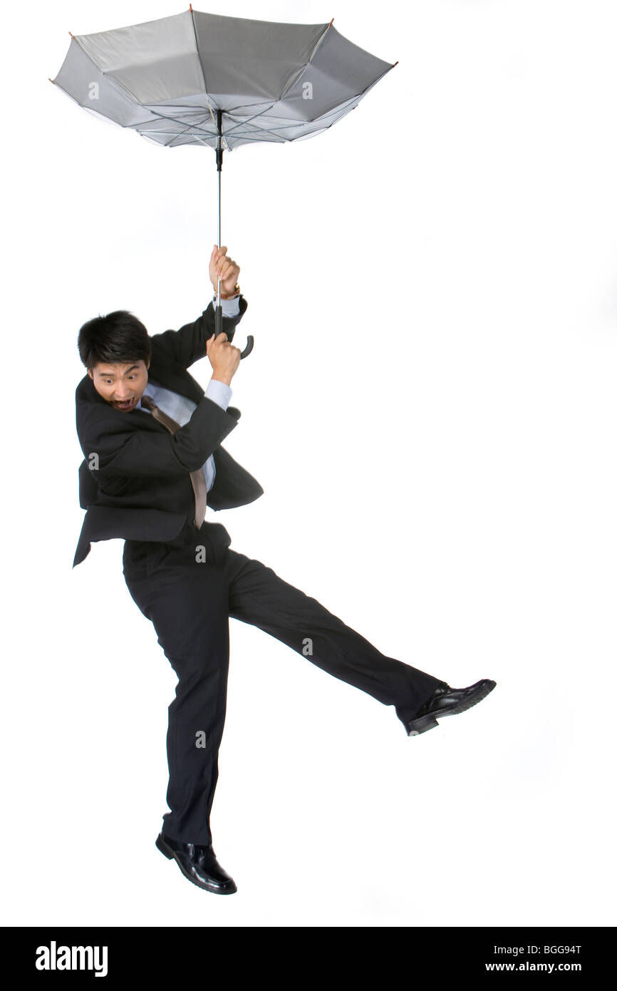 Young businessman dropping down by umbrella Stock Photo - Alamy