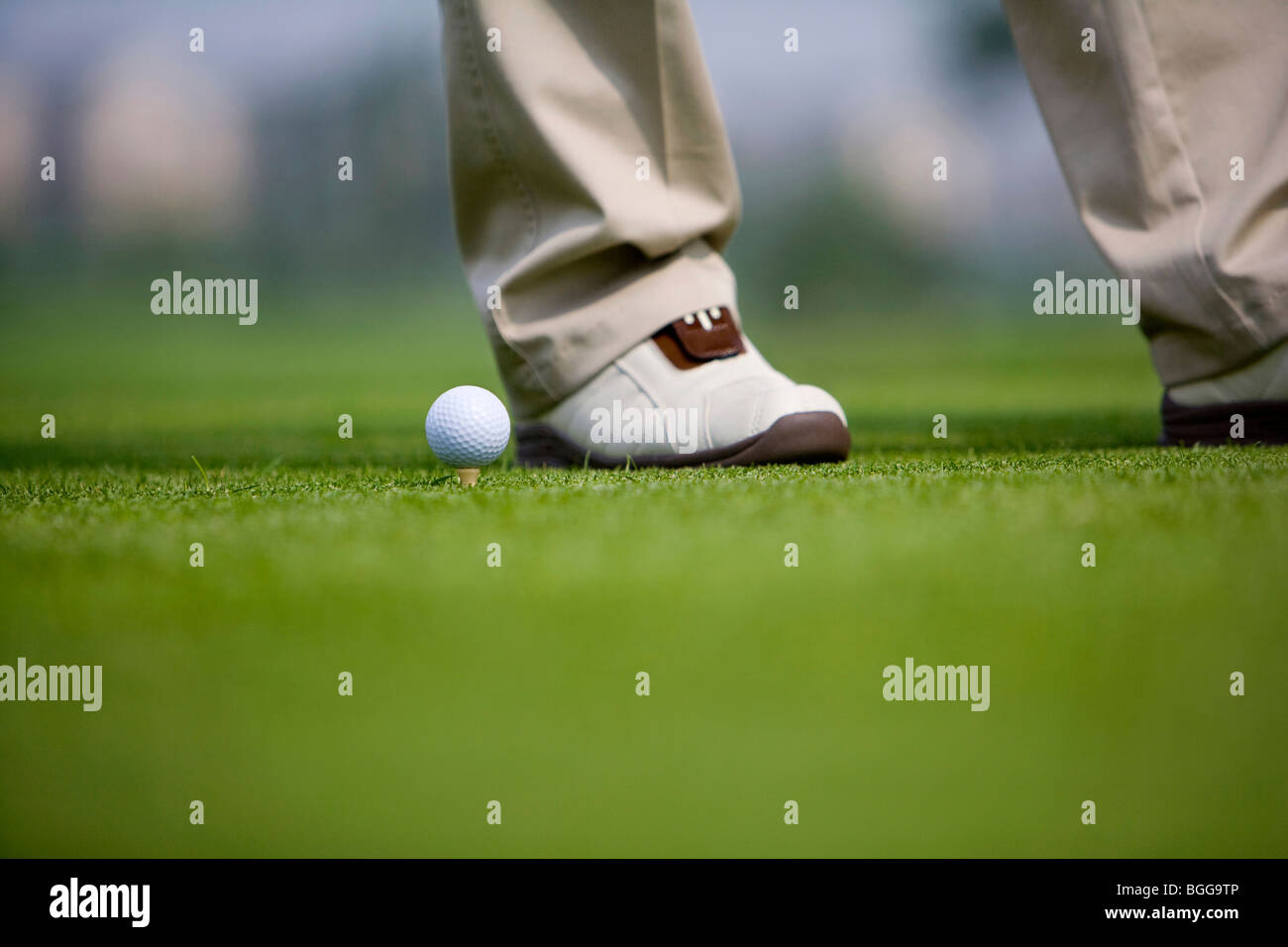 Close-up of a golf ball and Golfer's feet Stock Photo - Alamy