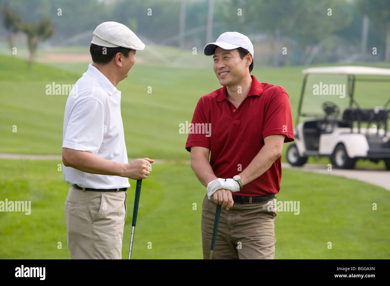 Two golfers chatting on the course Stock Photo - Alamy