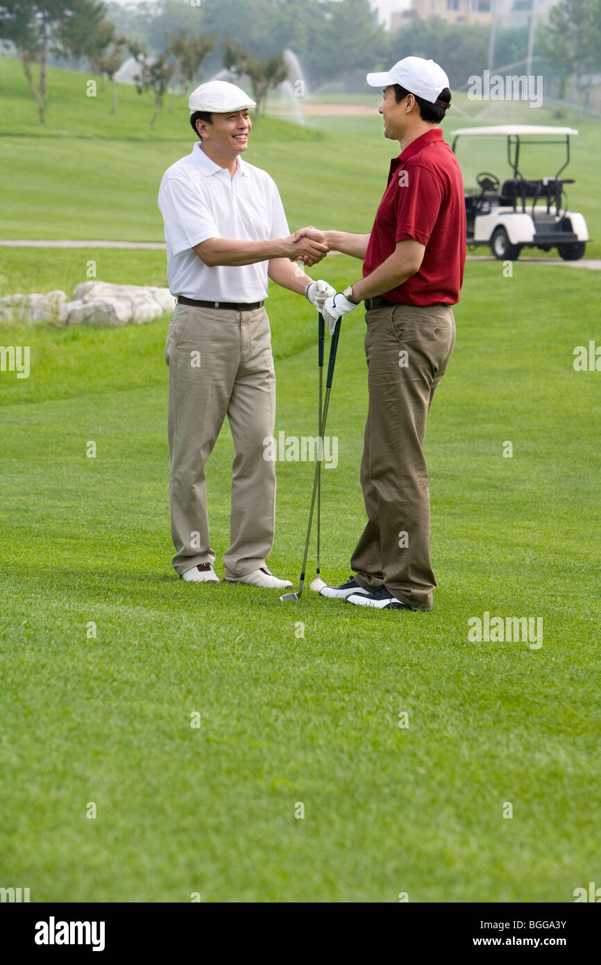 Two golfers shaking hands on the course Stock Photo - Alamy