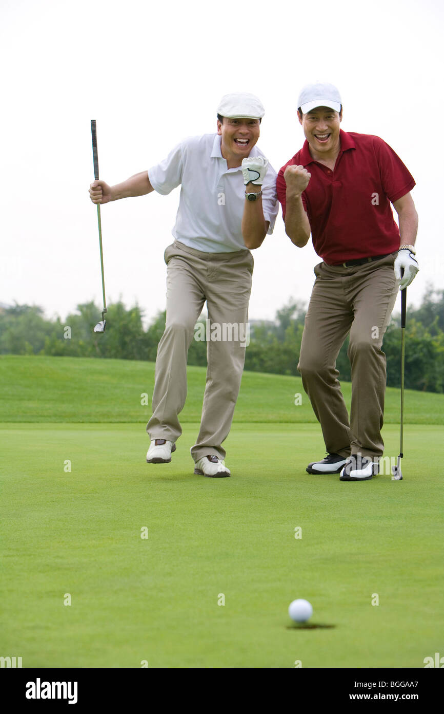 Two Golfers Celebrate a nice putt Stock Photo - Alamy