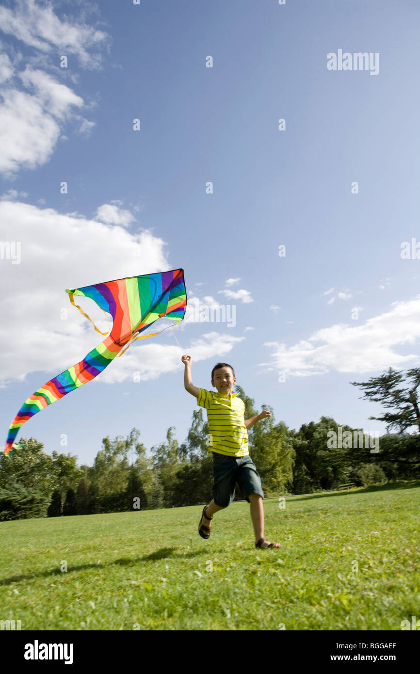 Young boy running with kite outdoors Stock Photo - Alamy