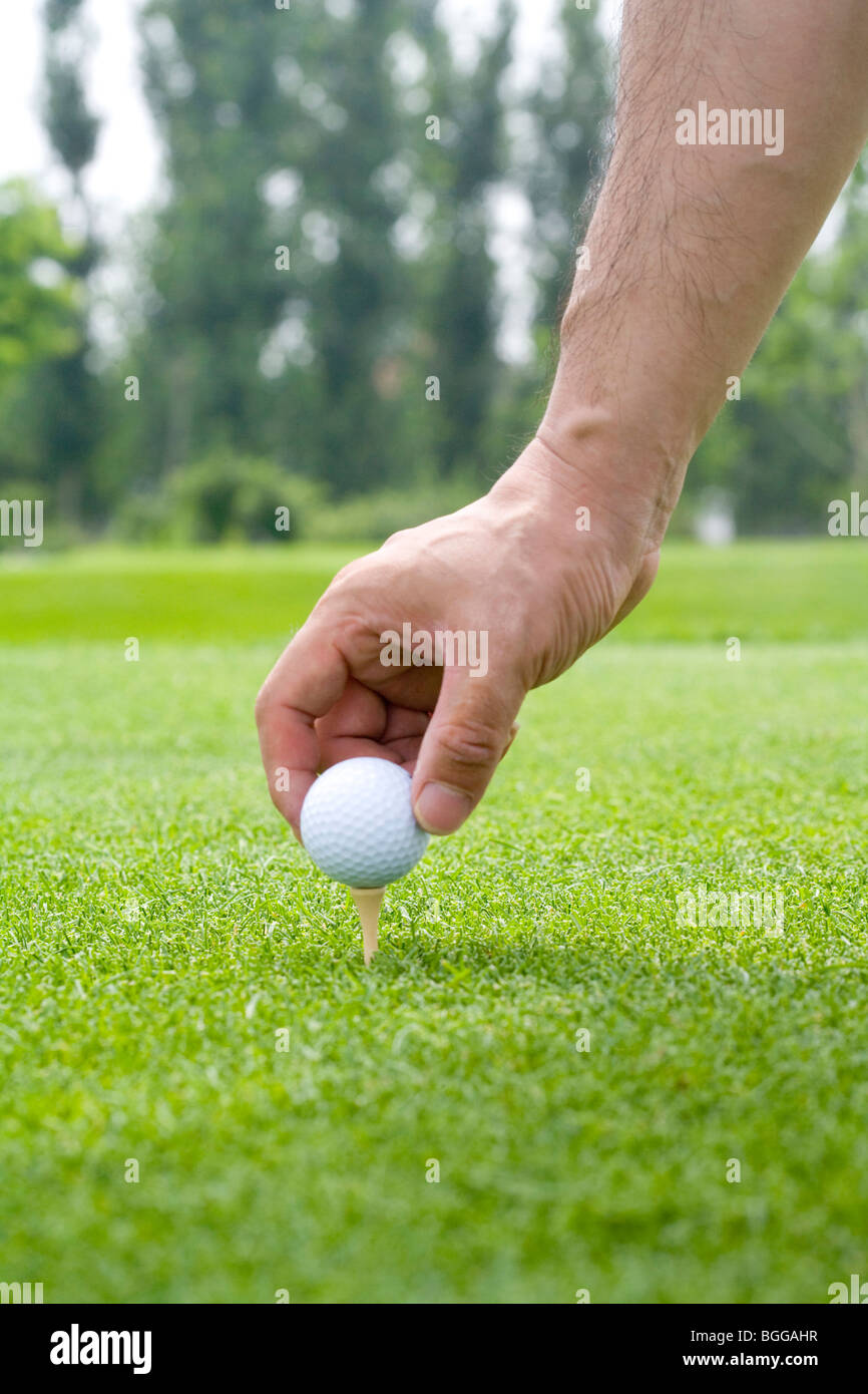 Close-up of putting a golf ball on tee Stock Photo - Alamy