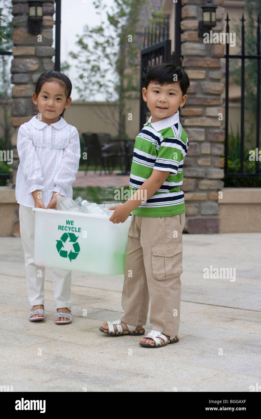 Children carrying recycling box Stock Photo - Alamy