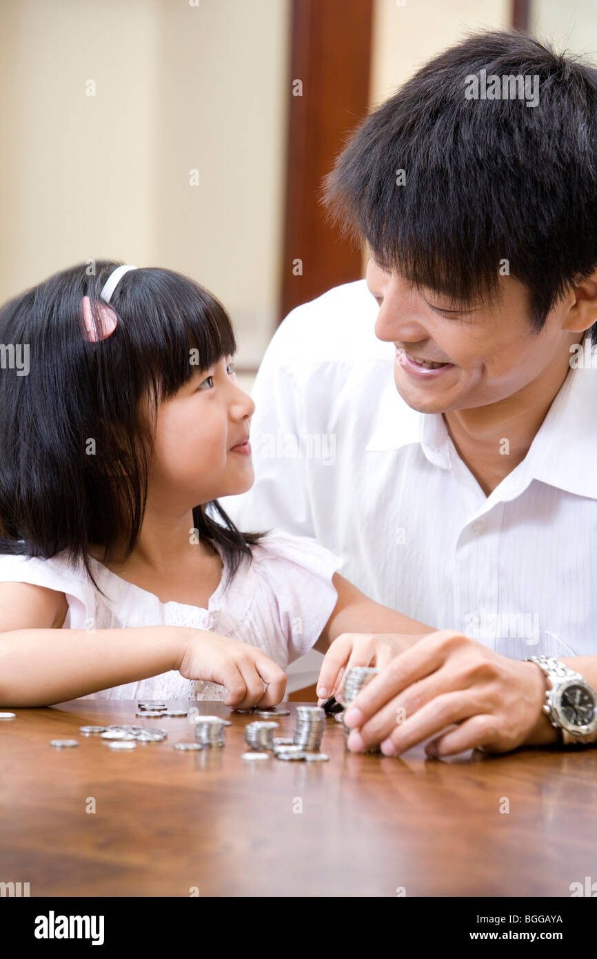 Father and daughter counting coins Stock Photo - Alamy