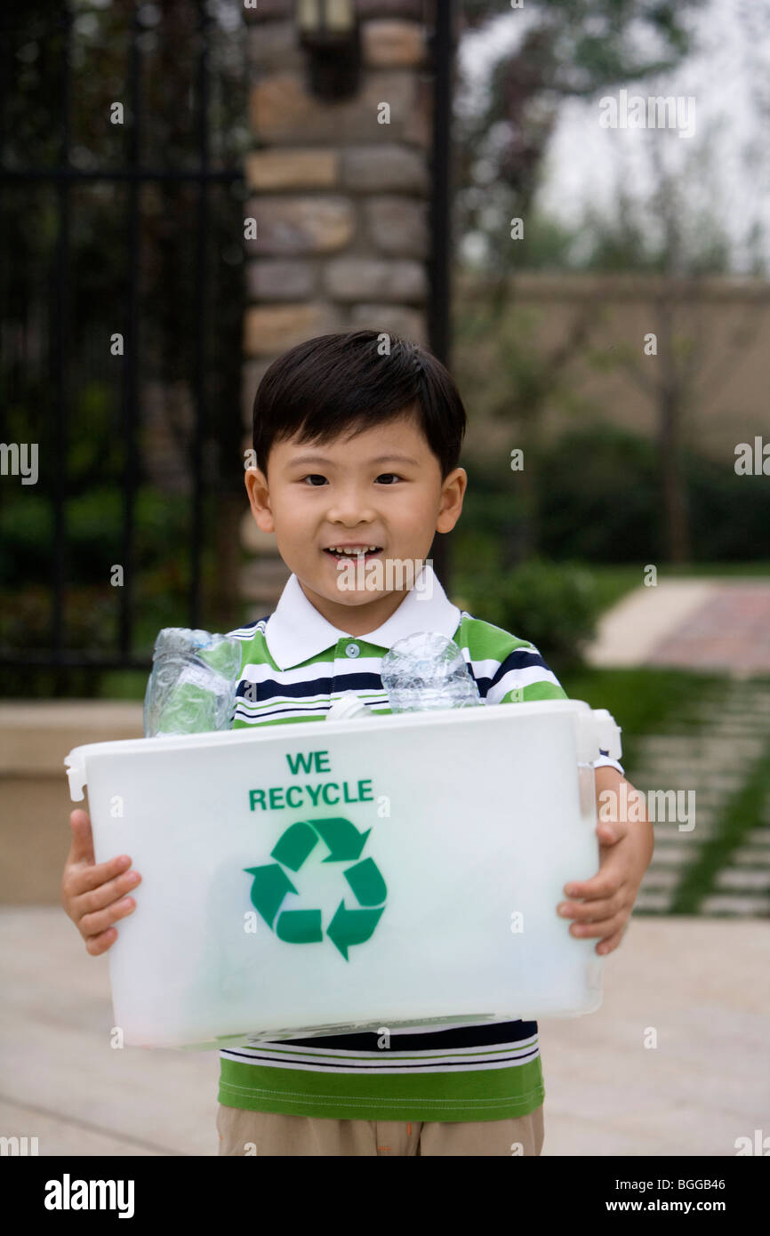 Little boy holding recycling box Stock Photo - Alamy