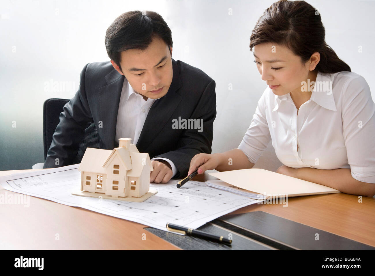 Businessmen with house model Stock Photo - Alamy