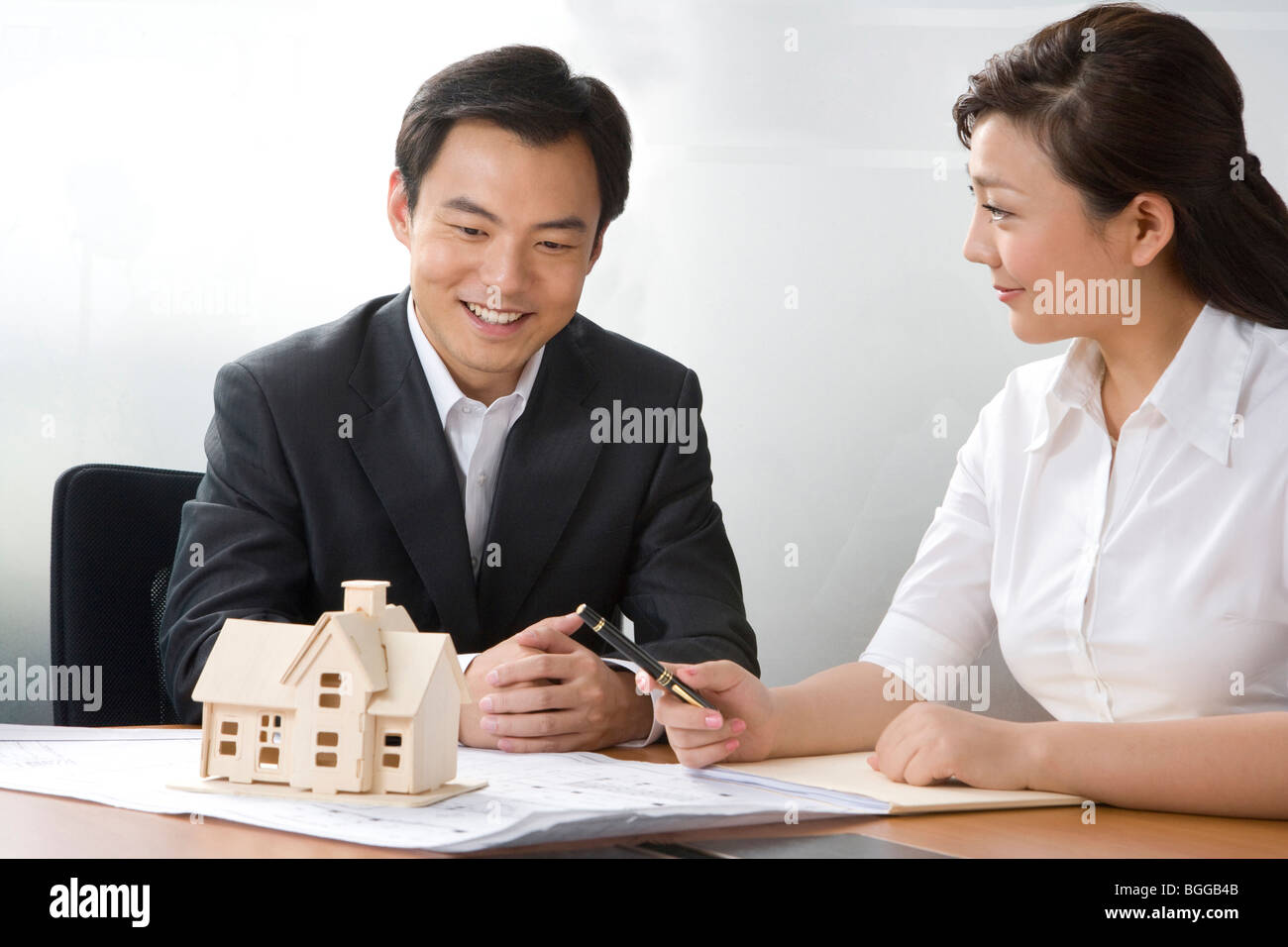 Businessmen with house model Stock Photo - Alamy