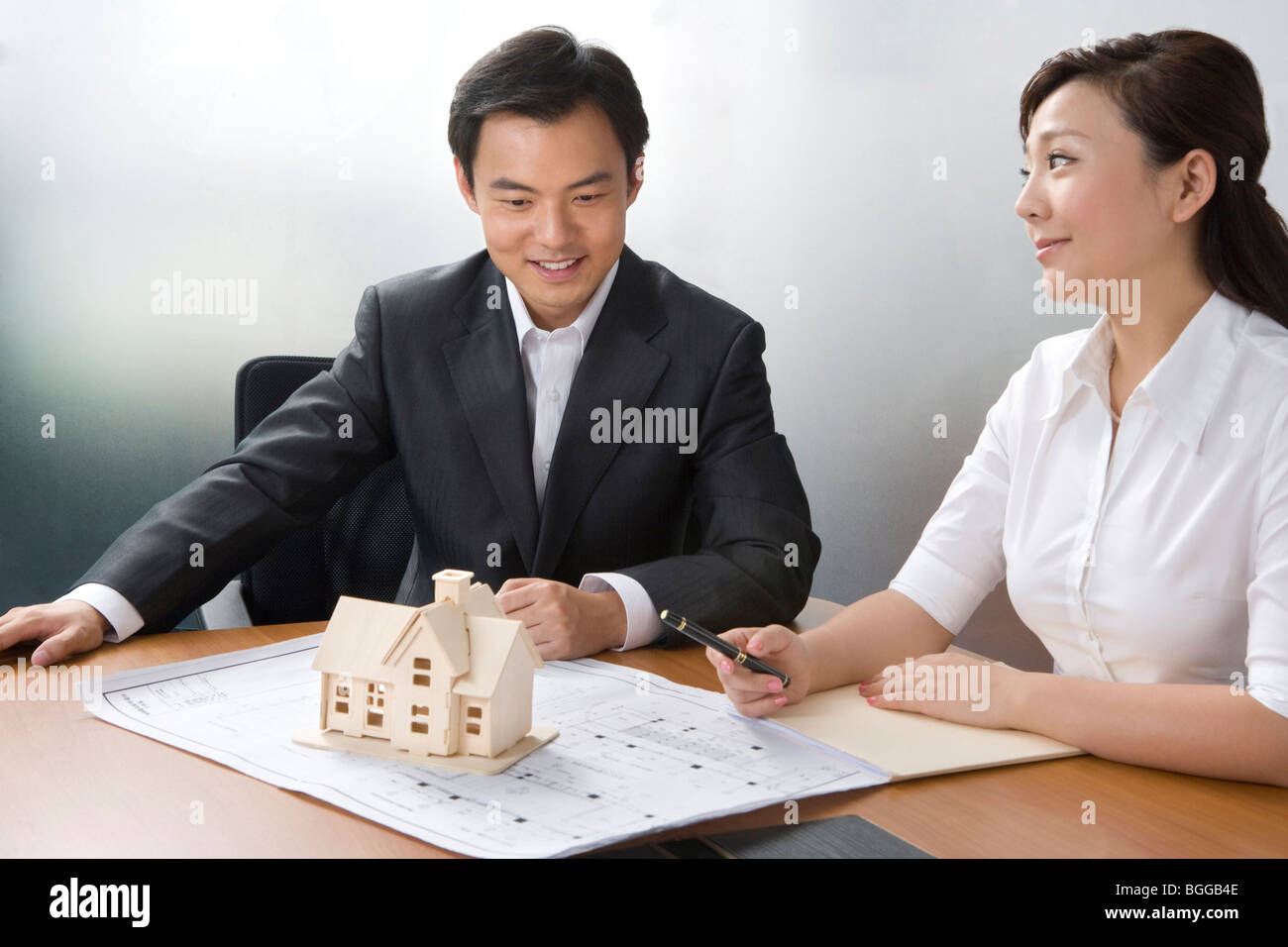Businessmen with house model Stock Photo - Alamy