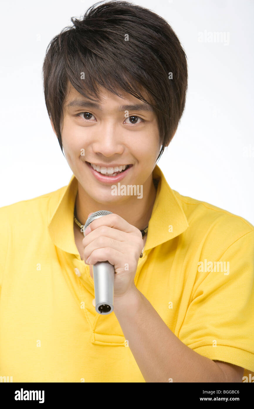 Young man singing with microphone Stock Photo - Alamy