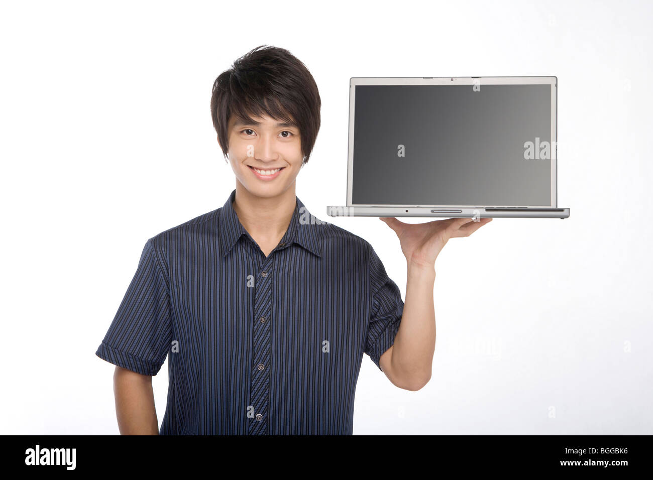 Young man holding laptop in hand Stock Photo - Alamy