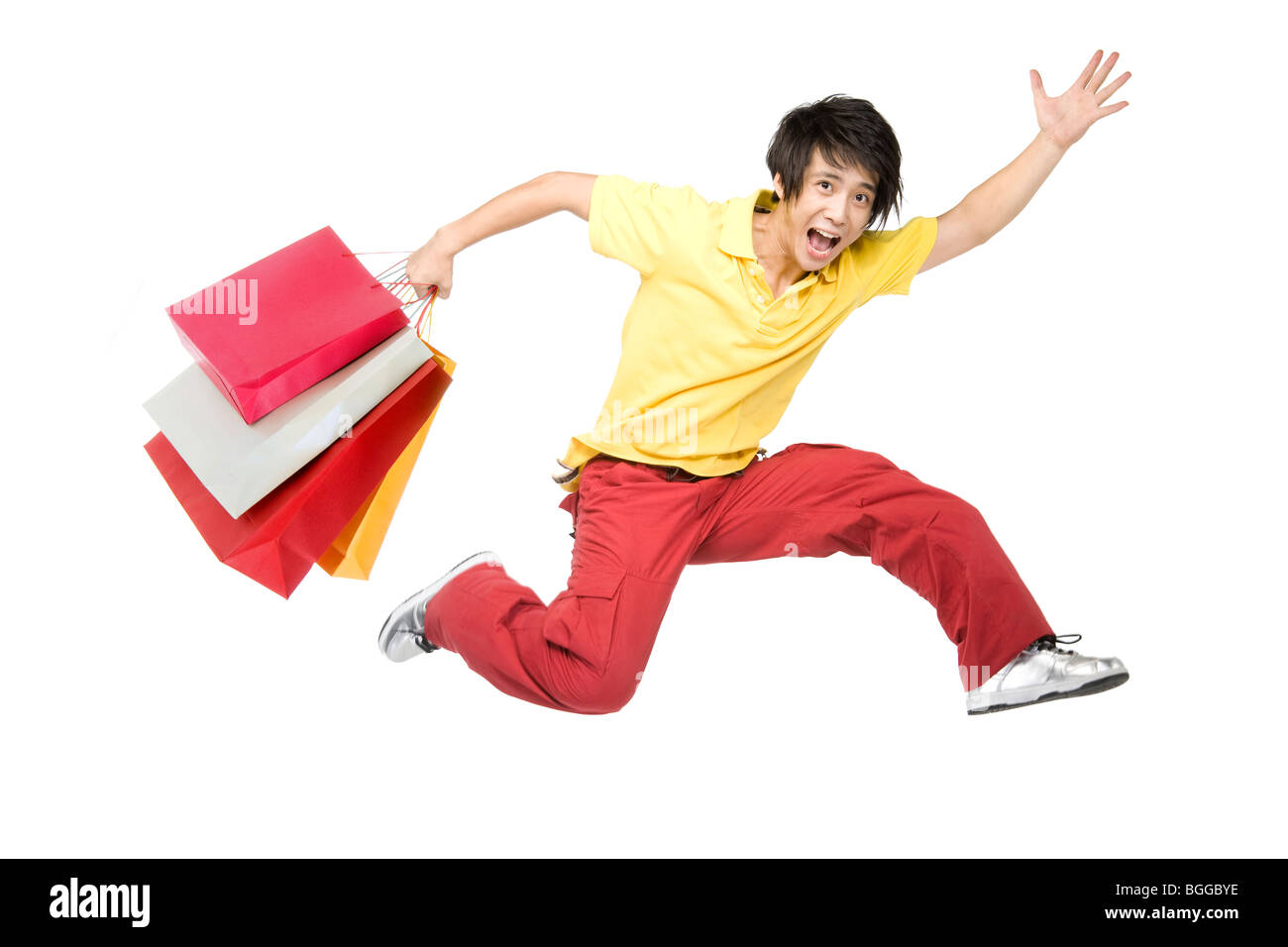Young man running with shopping bags Stock Photo - Alamy